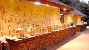 Bancada de tijolos com potes de mel e parede com desenhos decorativos.