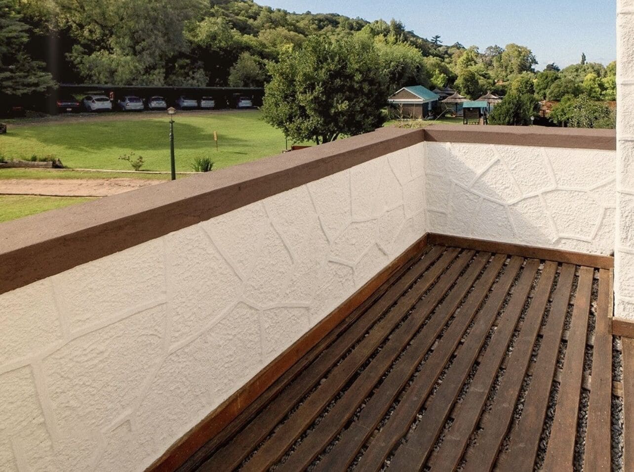 Varanda com parede texturizada e ripas de madeira.