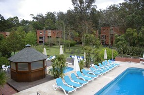 Uma área de piscina com espreguiçadeiras e um gazebo.
