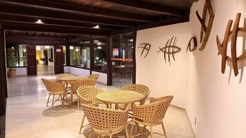 Um interior moderno com móveis de vime e arte abstrata nas paredes.
