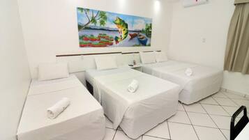 Quarto de hotel com duas camas, um quadro representando uma cena de pesca e piso de azulejos brancos.