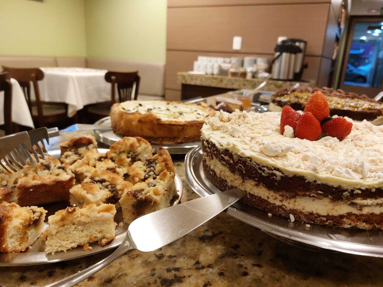 Buffet com diversos doces, incluindo bolos e tortas.