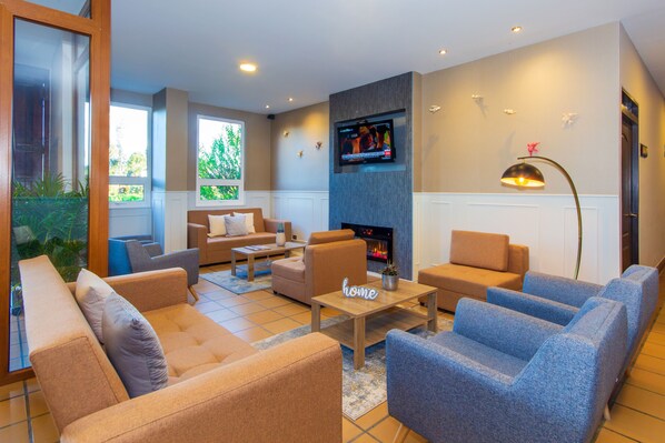 Uma sala de estar moderna com sofás, uma mesa de centro e uma lareira.