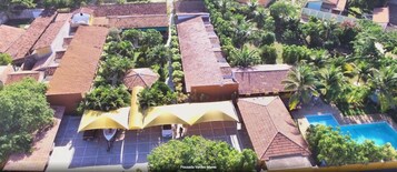 Um resort com vários edifícios, piscina e vegetação exuberante.
