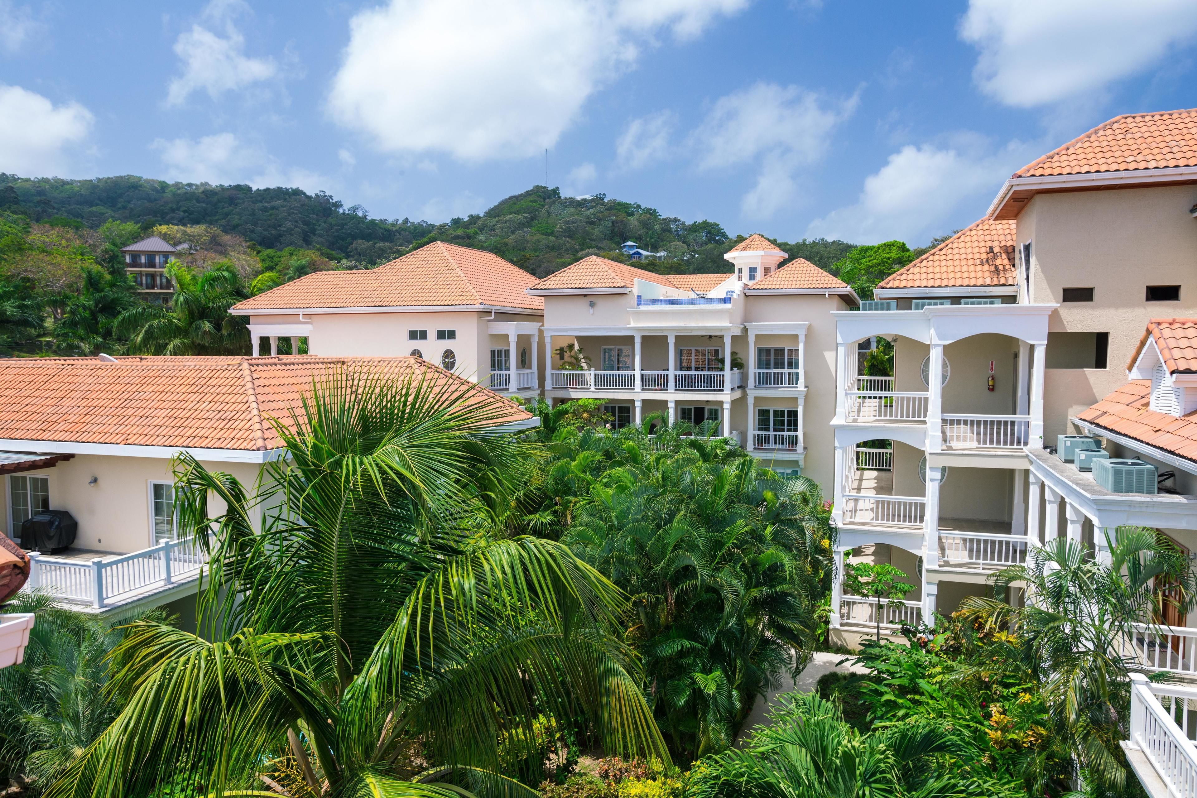 Um resort com vários edifícios, varandas e vegetação exuberante.