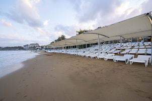 Praia particular, espreguiçadeiras, guarda-sóis, toalhas de praia