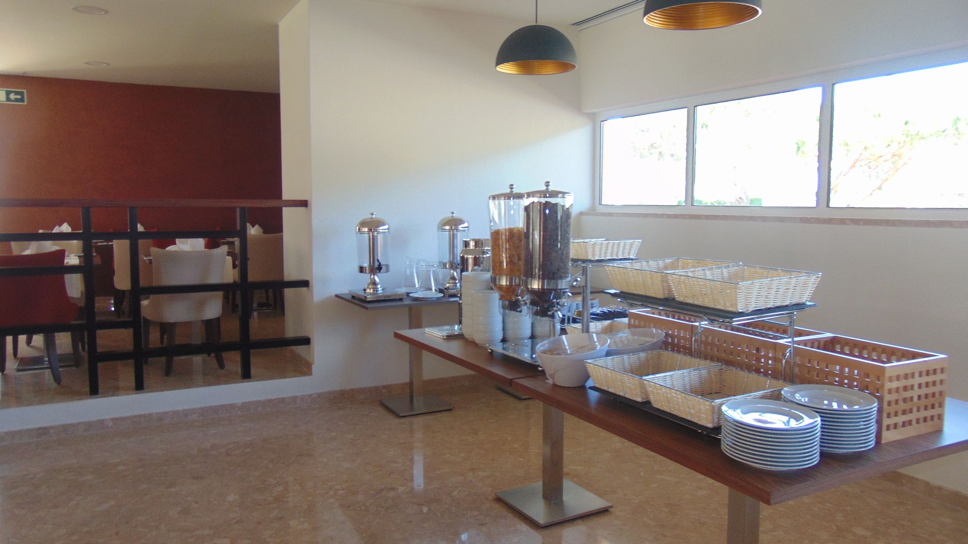 Disposição de buffet com diversos dispensadores de comida e bandejas de servir.