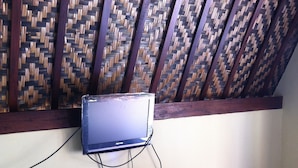 Uma mesa de madeira com uma televisão em cima, ligada a uma tomada na parede.