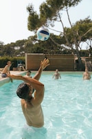 Piscina com pessoas jogando voleibol.