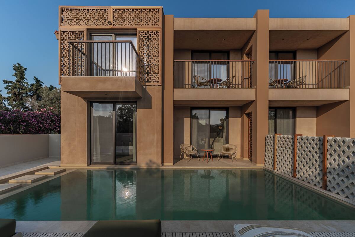 Um edifício moderno com piscina, varandas e área externa para sentar.