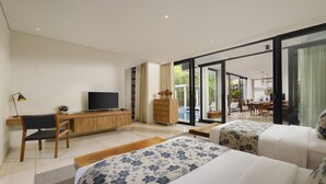 Quarto de hotel moderno com uma cama grande, uma mesa de trabalho com televisão, área de refeições e porta de vidro deslizante para o exterior.