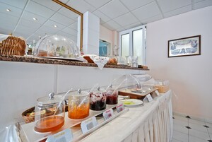 Disposição de buffet com diversas opções de comida e bebida, incluindo mel, damasco, cereja e morango.