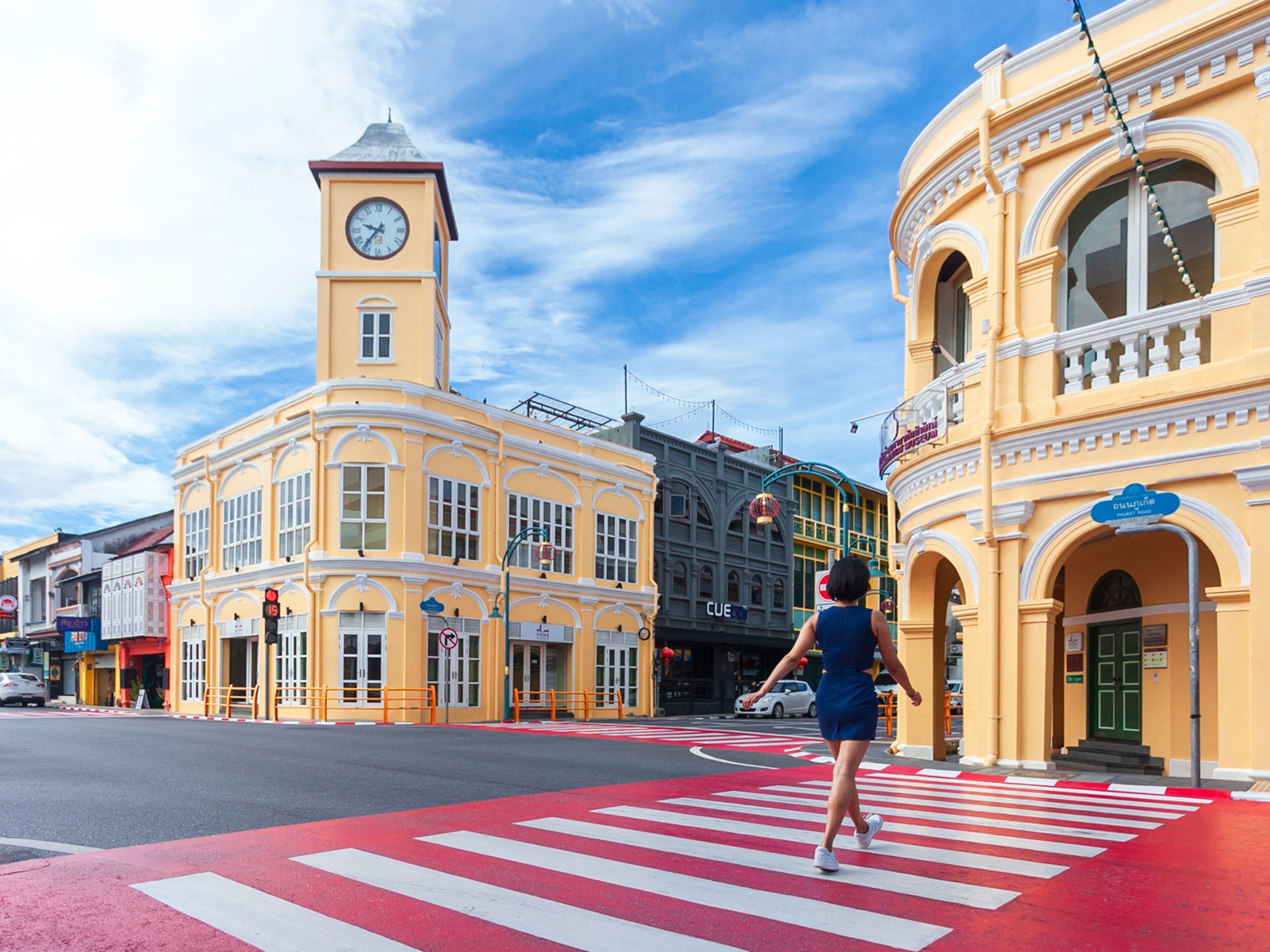 Rua com faixa de pedestres e edifícios de arquitetura clássica.