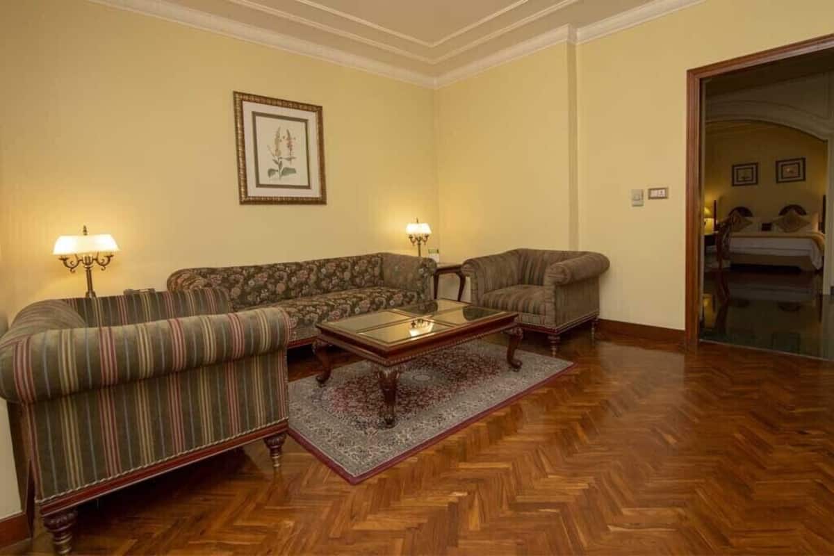 Quarto com dois sofás, uma mesa de centro de vidro e um tapete estampado.