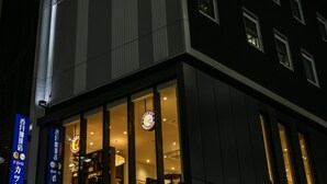 Um edifício moderno com uma característica vertical de iluminação marcante e grandes janelas.