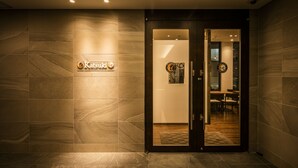 Entrada de hotel com uma placa que diz "Katsuki".
