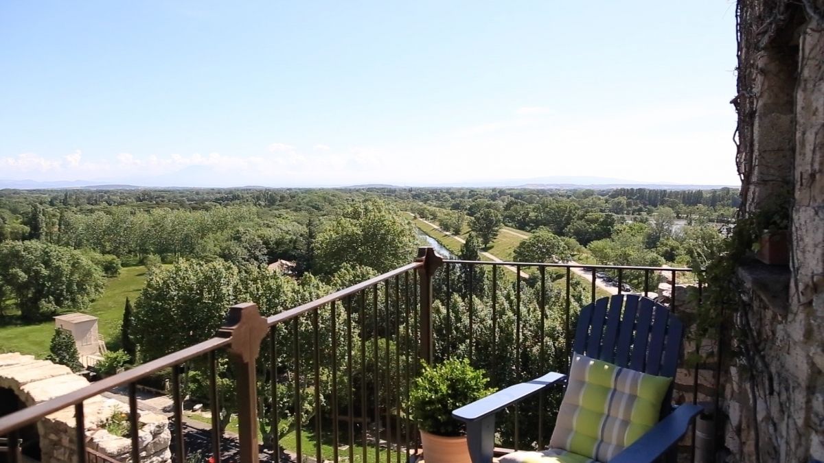 Uma varanda com vista para uma paisagem verdejante.