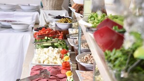 Uma mesa de buffet com diversos alimentos e utensílios.