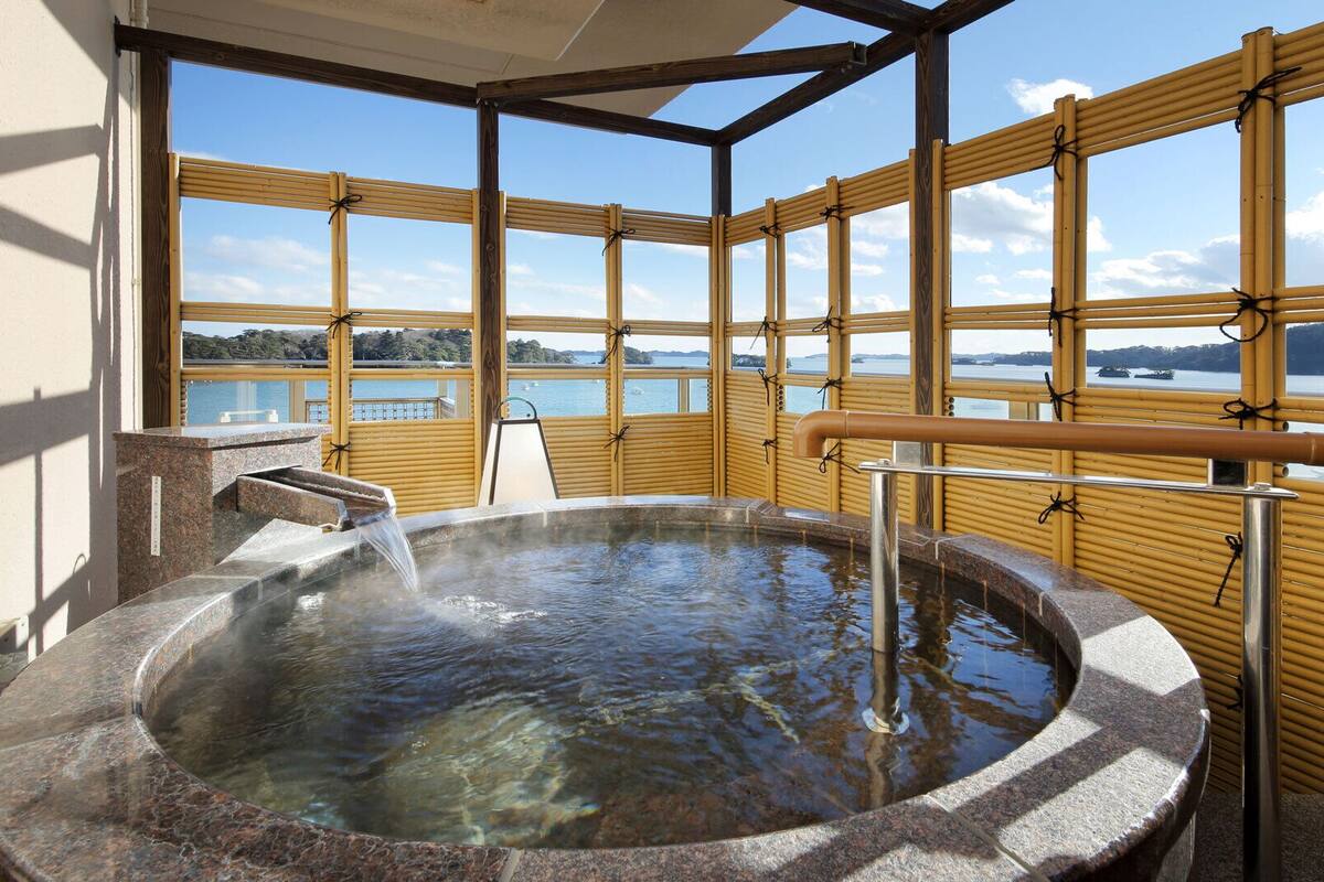 Uma banheira de hidromassagem com vista para um lago e montanhas.