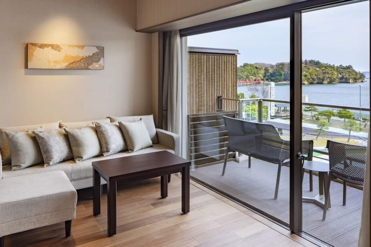 Uma sala de estar moderna com sofá, mesa e varanda com mobiliário de exterior.
