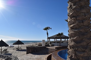 Na praia, praia de areia branca, espreguiçadeiras, guarda-sóis de praia