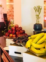Exposição de frutas com maçãs, uvas e bananas sobre uma mesa de madeira.