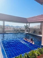 Piscina com duas pessoas relaxando.