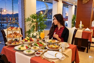 Uma mesa de jantar posta com diversos pratos, incluindo doces, frutas e uma bebida.