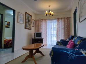 Apartamento, 3 quartos | Área de estar | TV de tela plana