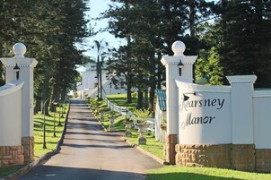 Uma passagem leva a um edifício com uma placa que diz 'Rearsney Manor'.