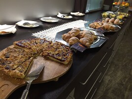 Buffet com diversos doces, incluindo tortas, pastéis e tigelas de frutas.