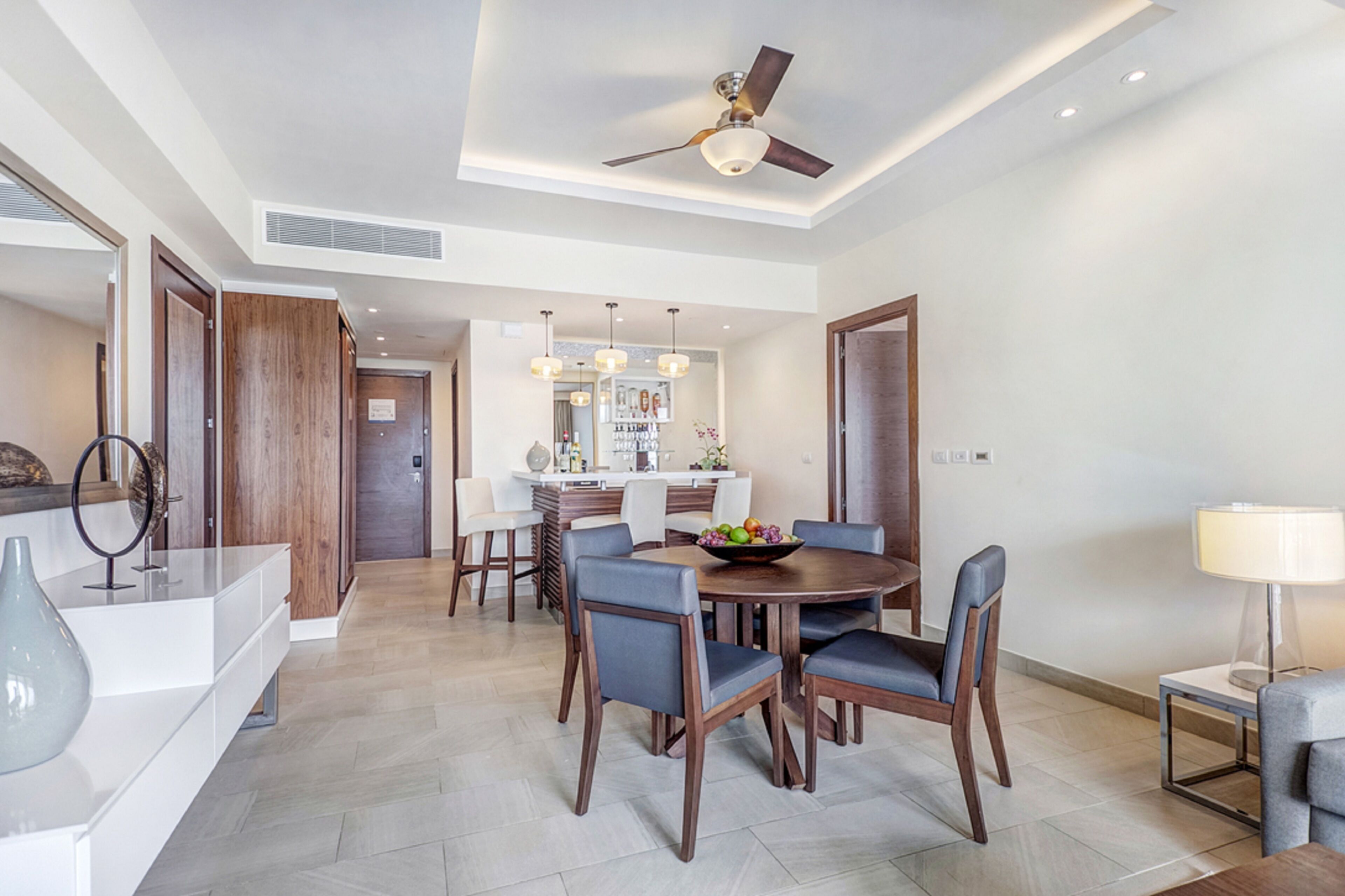 Uma área de refeições moderna com uma mesa redonda, seis cadeiras e um ventilador de teto.