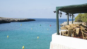 Um terraço à beira-mar com mesas ao ar livre e vista para o mar.