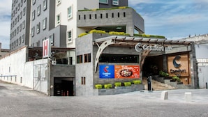 Um hotel moderno com uma placa Comfort Inn bem visível, uma entrada coberta e uma escadaria que leva à entrada.