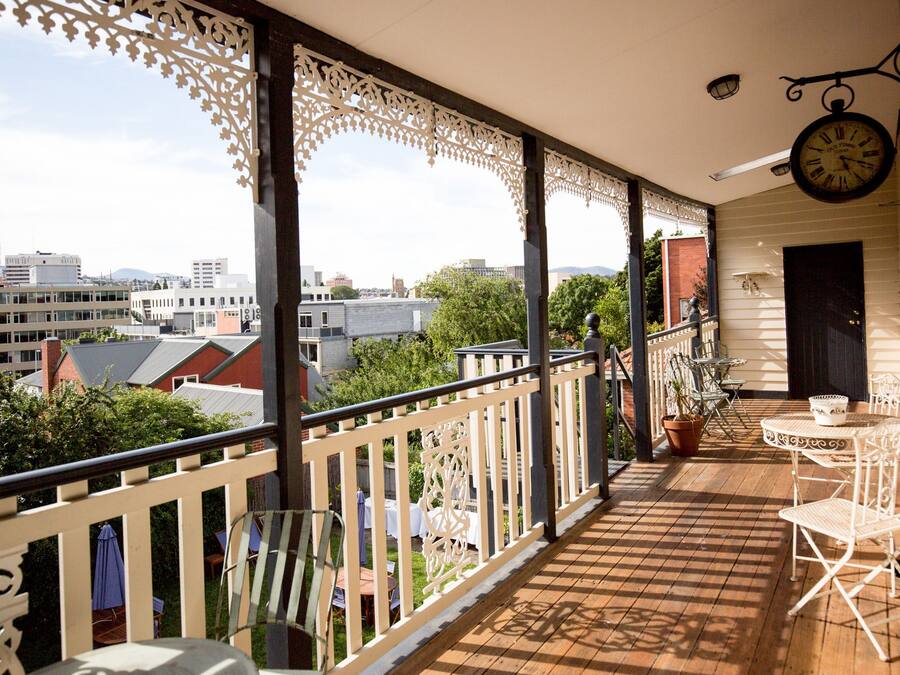 Varanda com vista para a cidade, um relógio e móveis de exterior.
