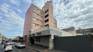 Hotel com fachada moderna, placa indicando proibição de entrada para táxis e céu claro.