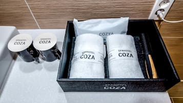Minibar de hotel spa com produtos de higiene pessoal da marca e uma garrafa de bebida alcoólica.