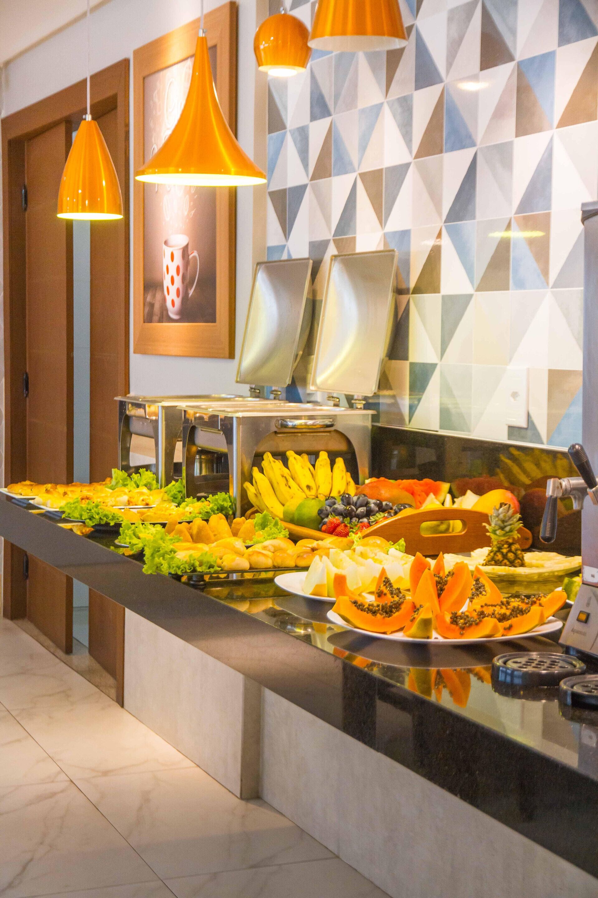 Um buffet com uma variedade de frutas e legumes, incluindo bananas, uvas e abacaxi.