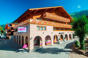 Um hotel Smarat Hotel com fachada de madeira, várias sacadas com caixas de flores e vista para os arredores.