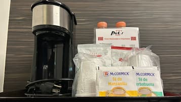 Uma cafeteira, duas garrafas de vinho e dois sachês de especiarias McCormick em um tabuleiro.