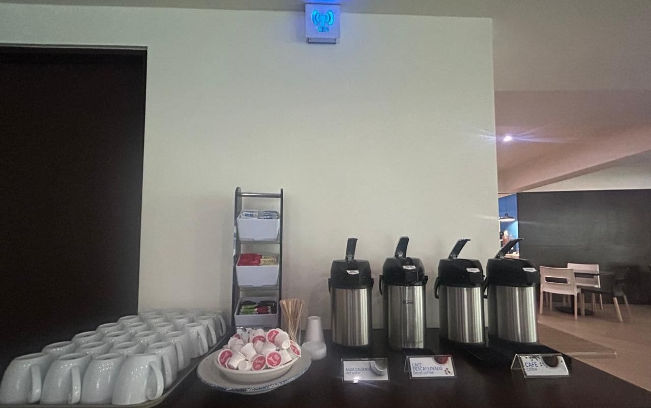 Estação de café com várias máquinas de café e uma bandeja de canecas.