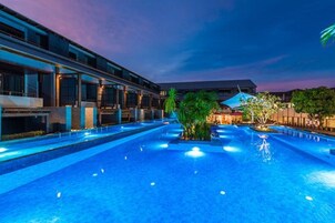 Piscina com um edifício moderno ao fundo.