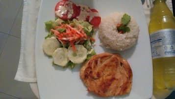 Um prato com salada, arroz e um hambúrguer grelhado.