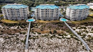 Hotel moderno com vários sacadões, piscina central e acesso à praia.