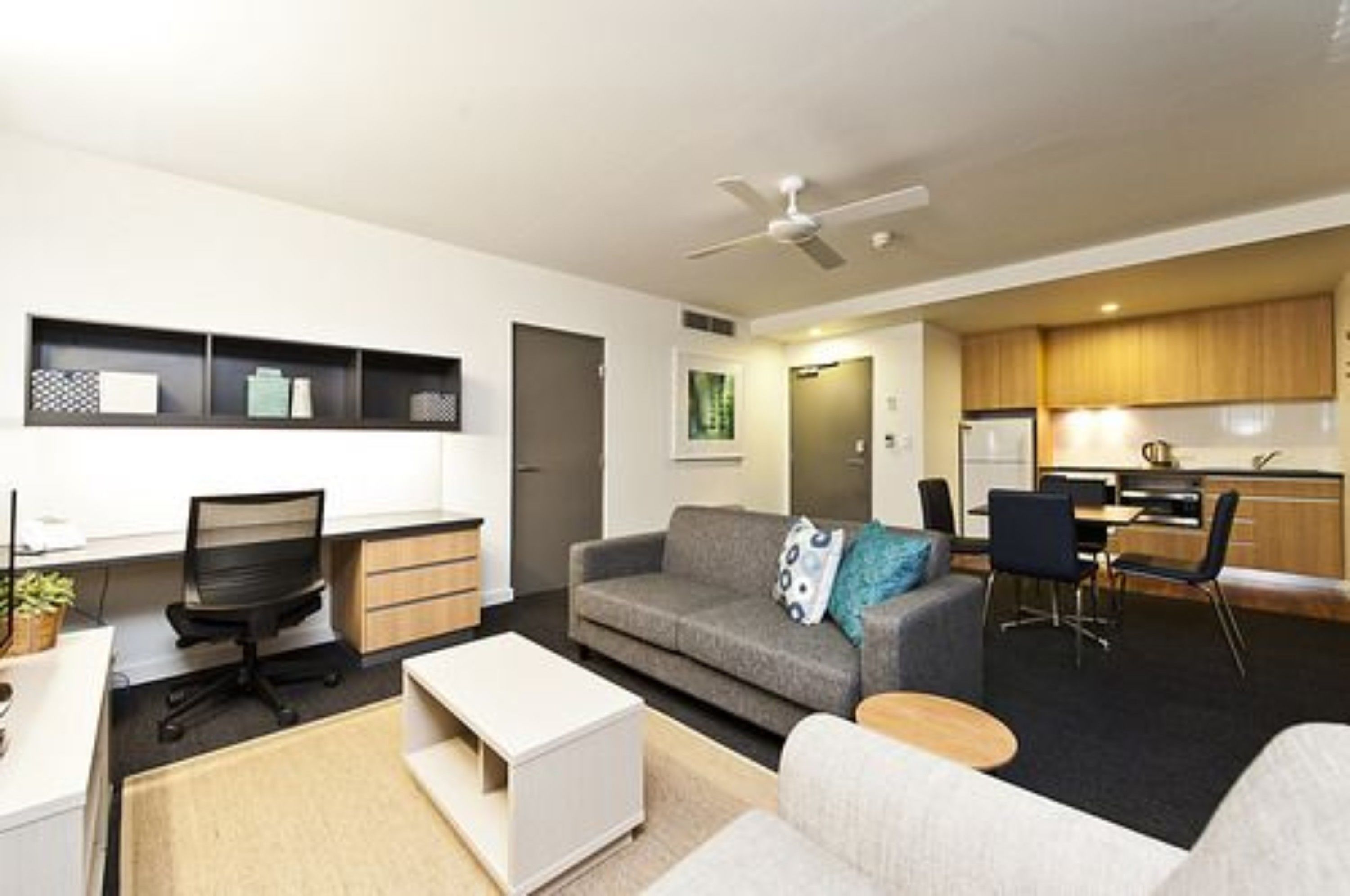 Um apartamento moderno com sala de estar, espaço para escritório e cozinha.