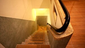 Uma escadaria com corrimão e uma luz no topo.
