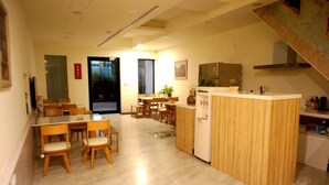 Uma cozinha compacta com uma ilha central, mesa de jantar de madeira e cadeiras.
