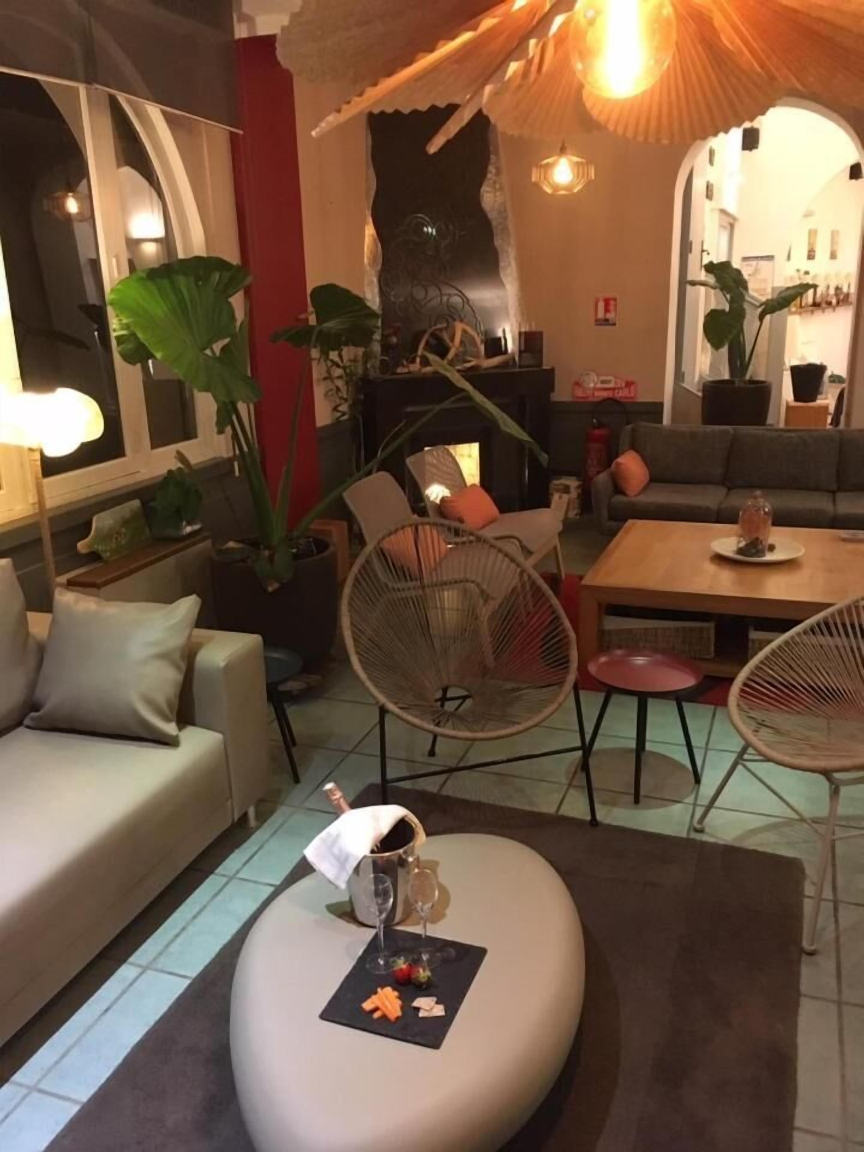 Uma área de estar aconchegante com um sofá, cadeiras, uma mesa de jantar e uma lareira.