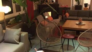 Uma área de estar aconchegante com um sofá, cadeiras, uma mesa de jantar e uma lareira.