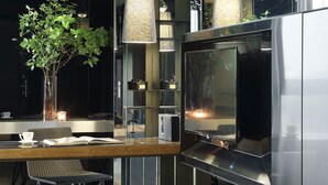 Cozinha moderna com uma ilha grande, luminárias pendentes e uma janela ampla.